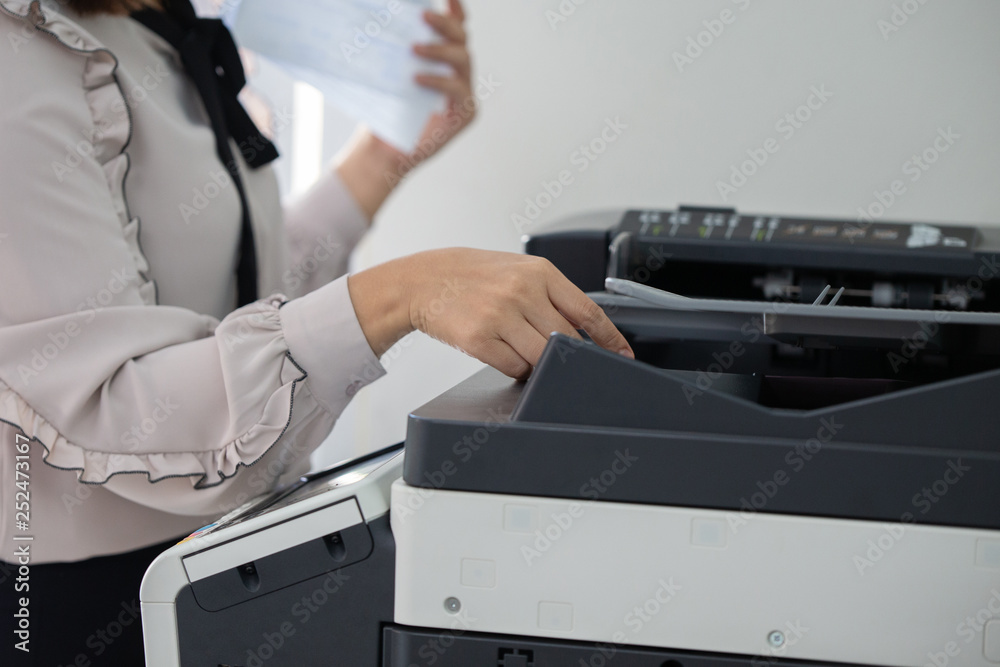 Young working woman using copier machines for copy or scan documents ...