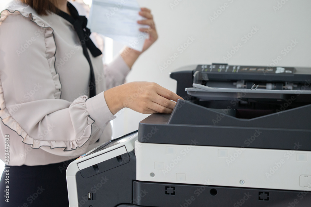 Young working woman using copier machines for copy or scan documents ...
