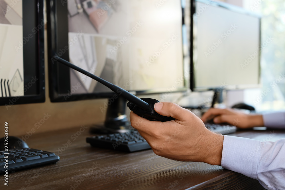 Male security guard with portable transmitter at workplace, closeup ...