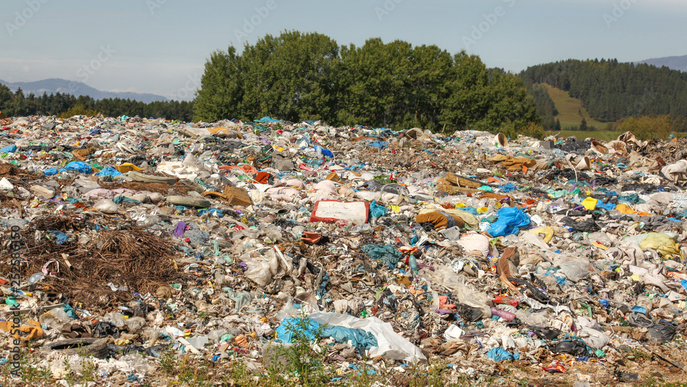 Landfill / dump site with green trees in background. No logos ...