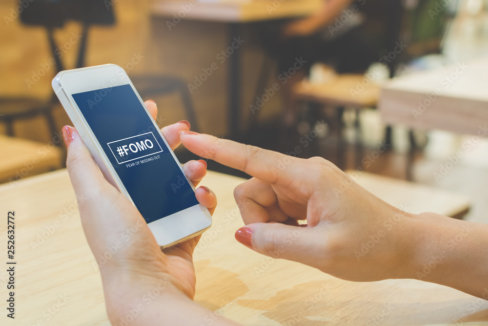 FOMO, fear of missing out concept. Female hand holding smartphone Stock ...