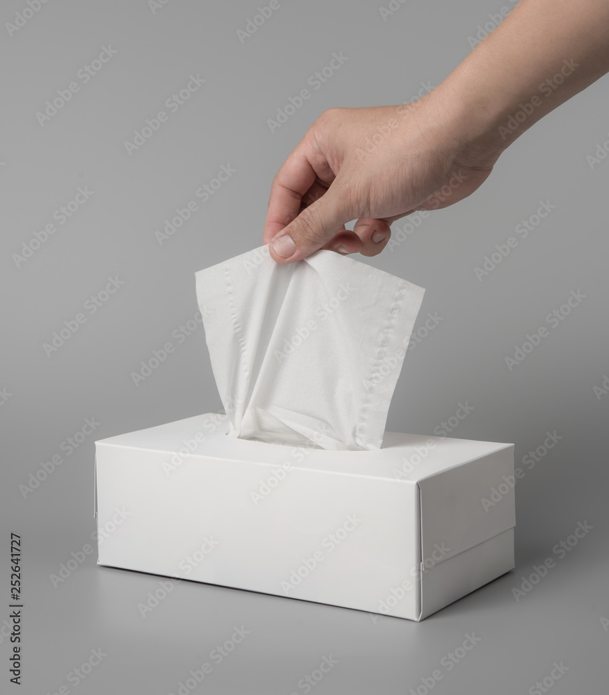 female hand pulling white facial tissue on grey background for print ...