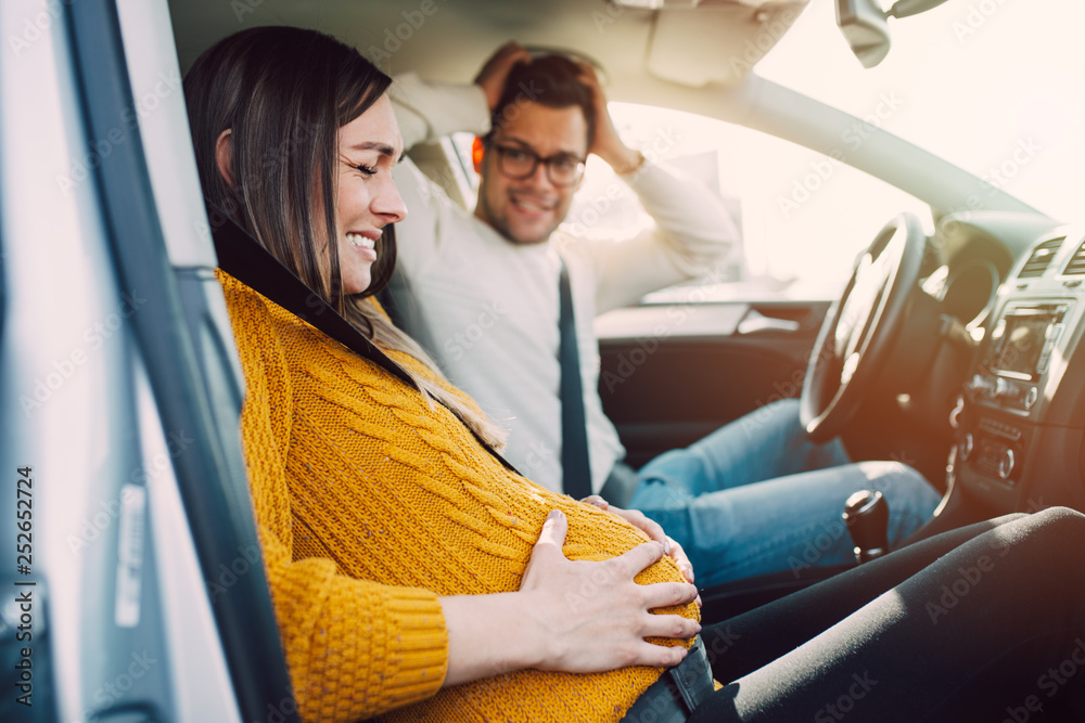 Pregnant woman starting to feel pain and contractions while her worried ...