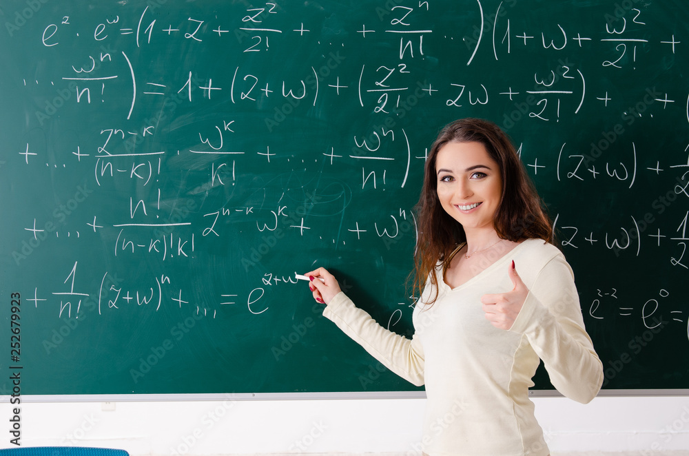 Young female math teacher in front of chalkboard Stock 사진 | Adobe Stock