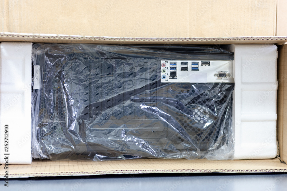 unpacking black personal computer, back view, cellophane packaging ...