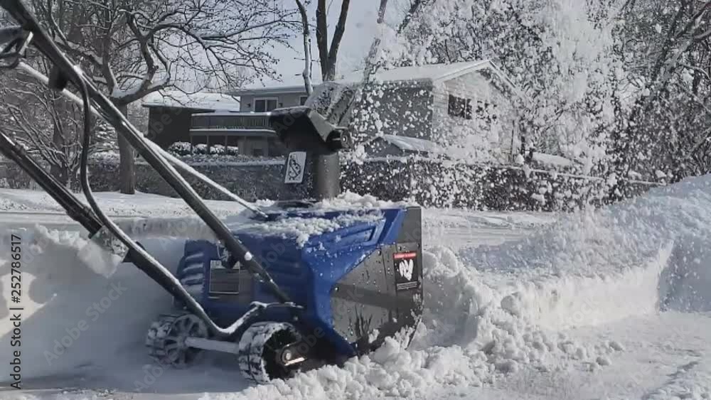 Close up and super slow motion of electric corded blue snowblower ...