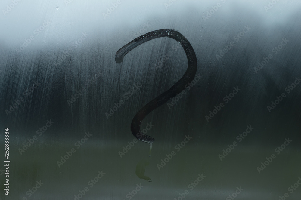 A question mark is drawn with a finger on a misted window. The question ...