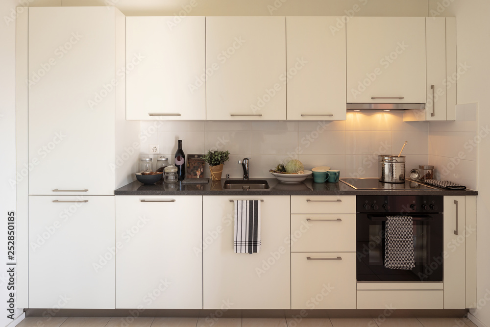 Front view of white modern kitchen with lights on Stock Photo | Adobe Stock