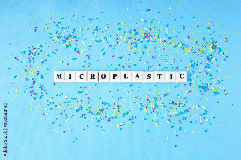 Plastic block cube with word MICROPLASTIC around small plastic ...