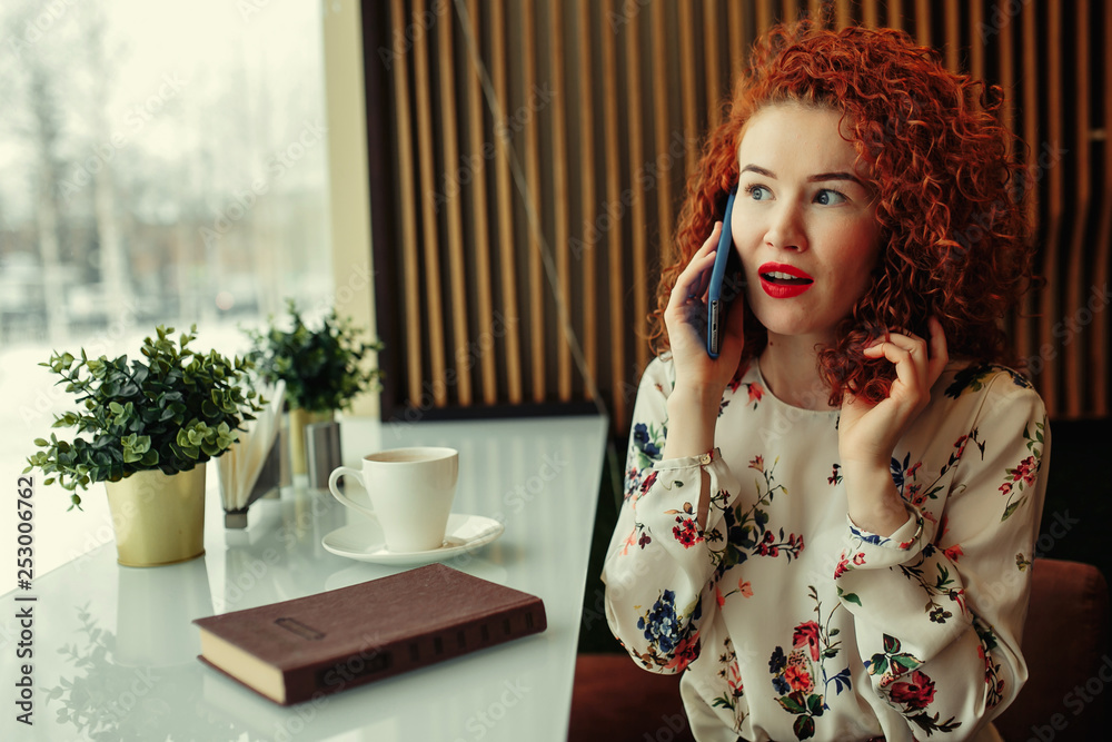 Young charming woman calling with cell telephone while sitting alone in ...