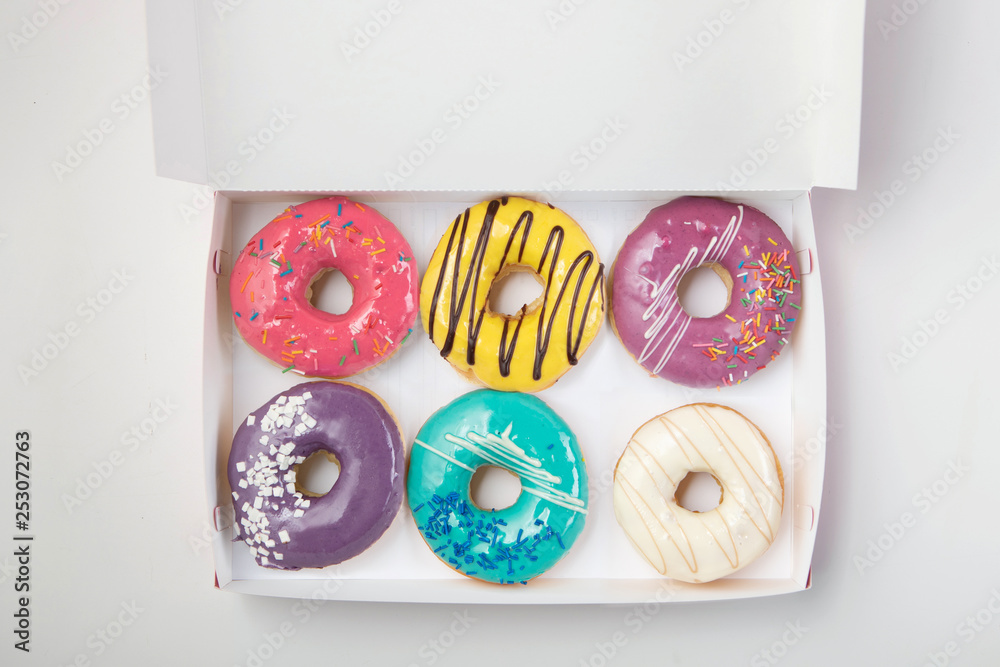 Six donuts with glaze in different colors in a white box Stock Photo ...