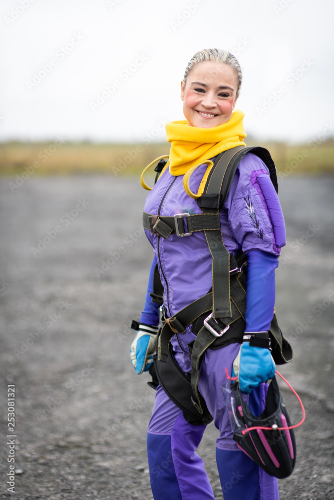 Pretty woman happy, dressed in jumpsuit and parachute harness on ...