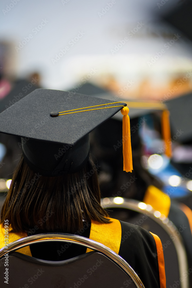 Rear view selective focus of the university graduates crowded in the ...