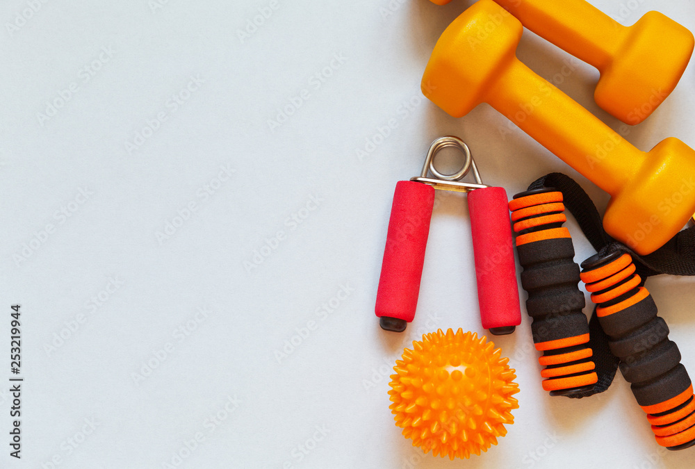 Bright orange equipment for physical exercise: dumbbells, chest ...