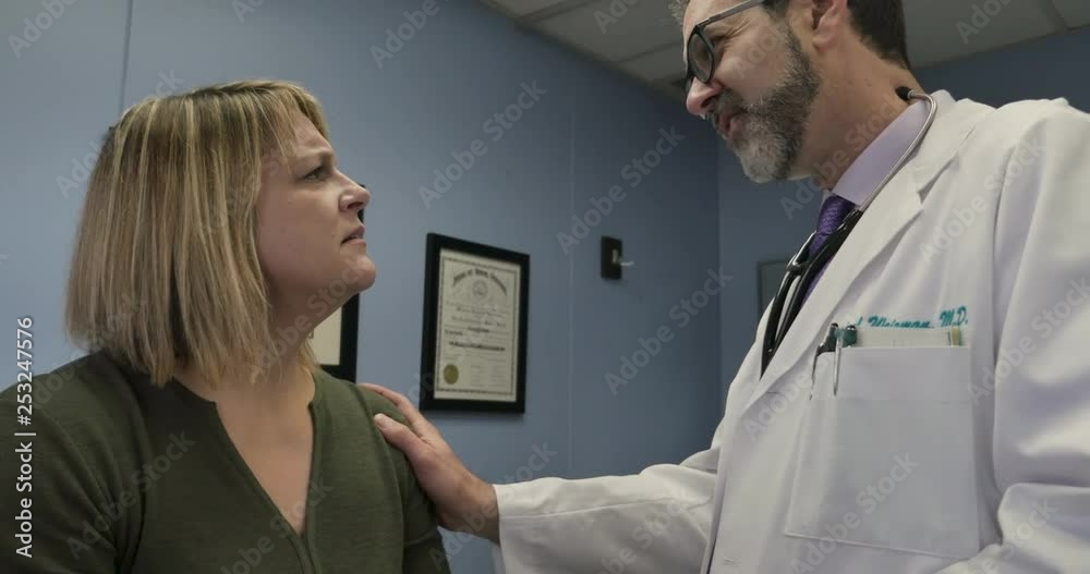 Doctor talking to a patient while she reacts in a serious sad manner ...