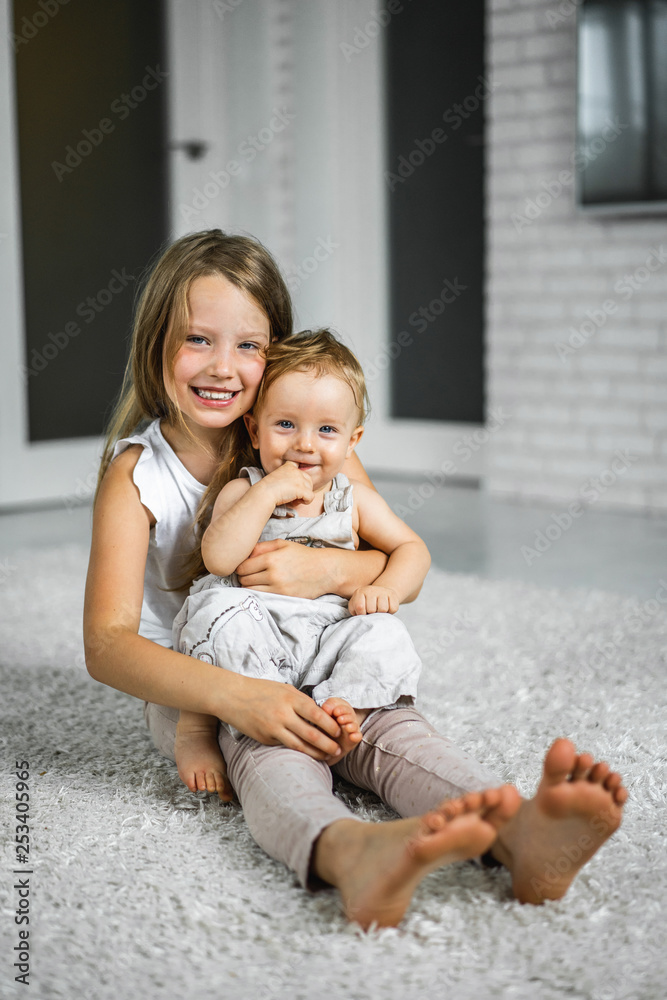 sister is messing with her younger brother. Sister is holding a little ...