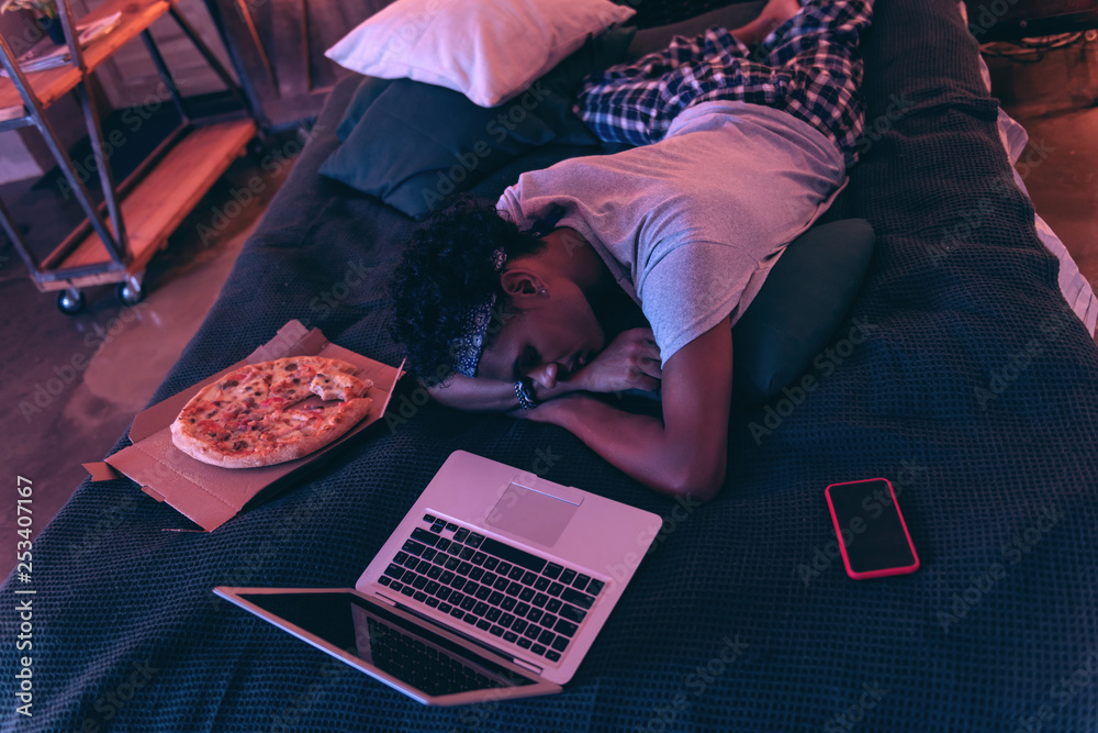 Guy was tired so he didn't even eating pizza and falling asleep with ...