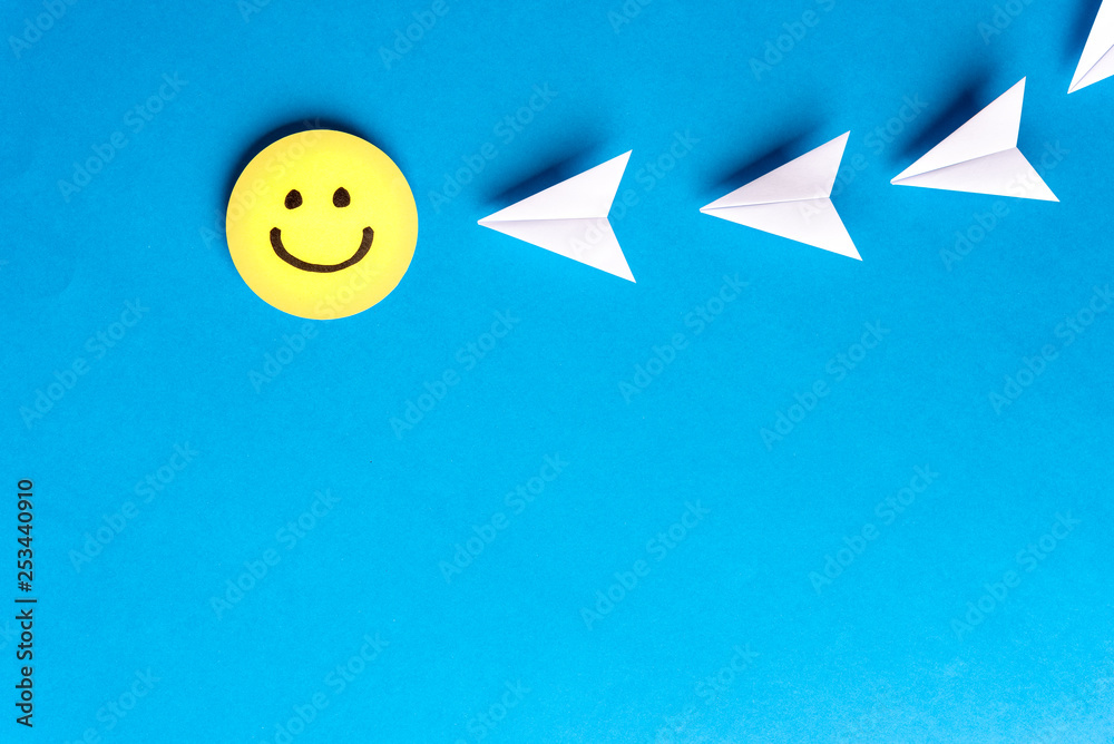 Emoticon yellow happy smiling face with paper airplanes on blue ...