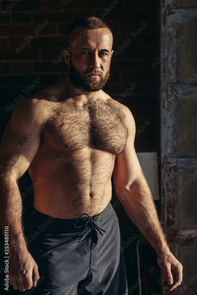 Portrait of shirtless athletic bare chested male showing biceps and ...