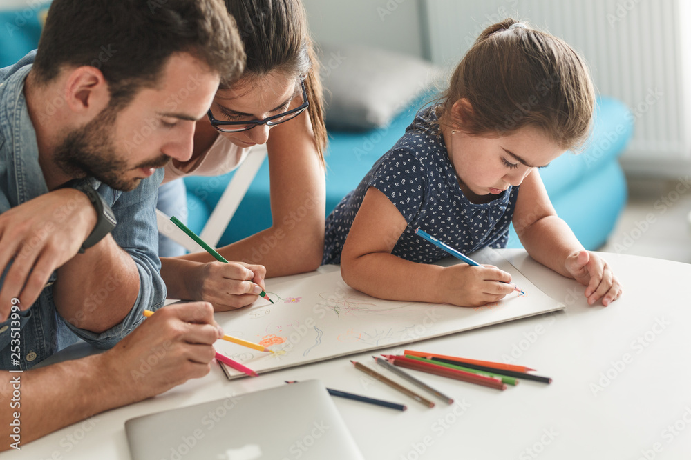 Father and mother teach daughter to draw.They sitting in living room ...