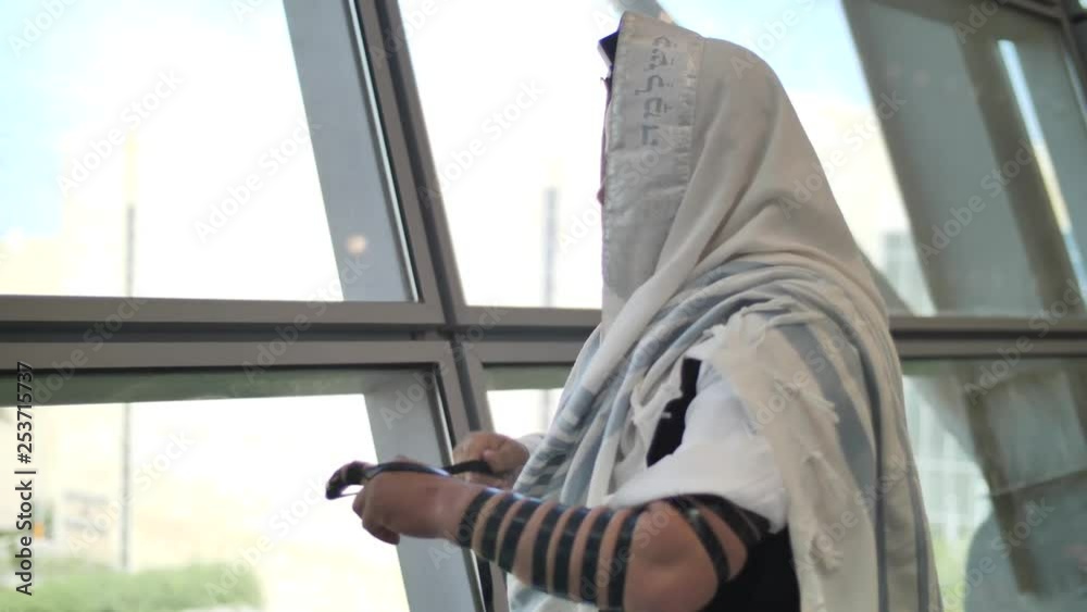 Jewish man with a prayer shawl Tallit use Tefillin. wrapping his hand ...