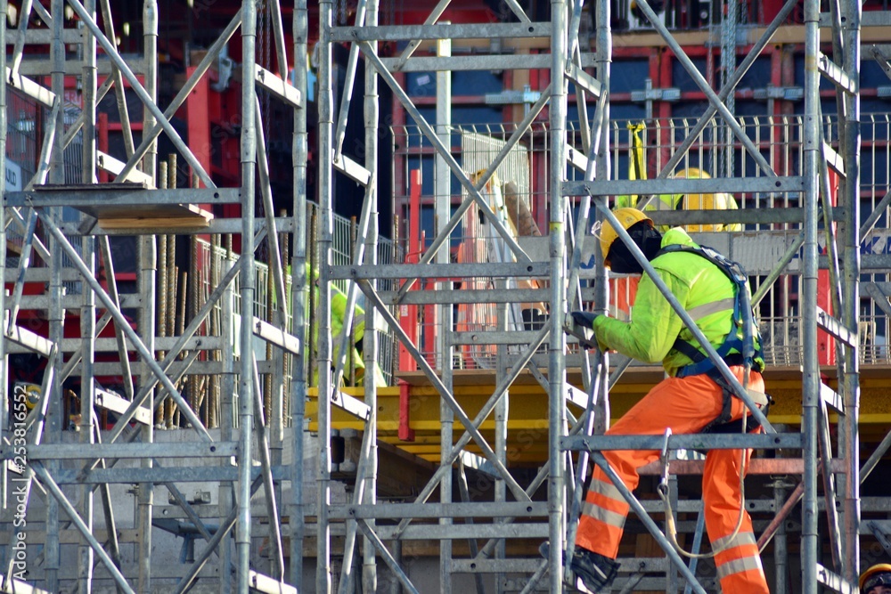 Construction workers working on scaffolding Stock Photo | Adobe Stock