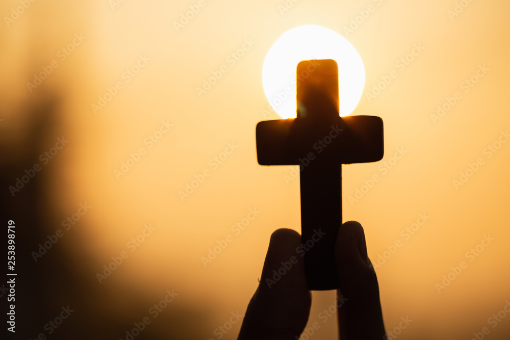 Foto de Silhouette of woman hands praying with cross in nature sunrise ...