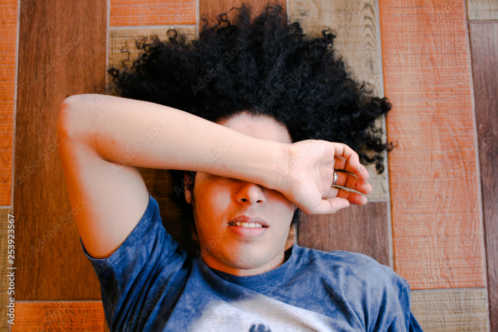 Boy smiling with his arm over his face Stock Photo | Adobe Stock