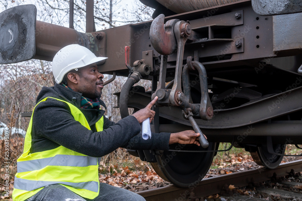 Afro-American train mechanic wearing safety equipment (helmet and ...