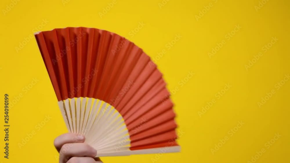 Moving a red paper fan to create a gentle refreshing wind, then folding ...