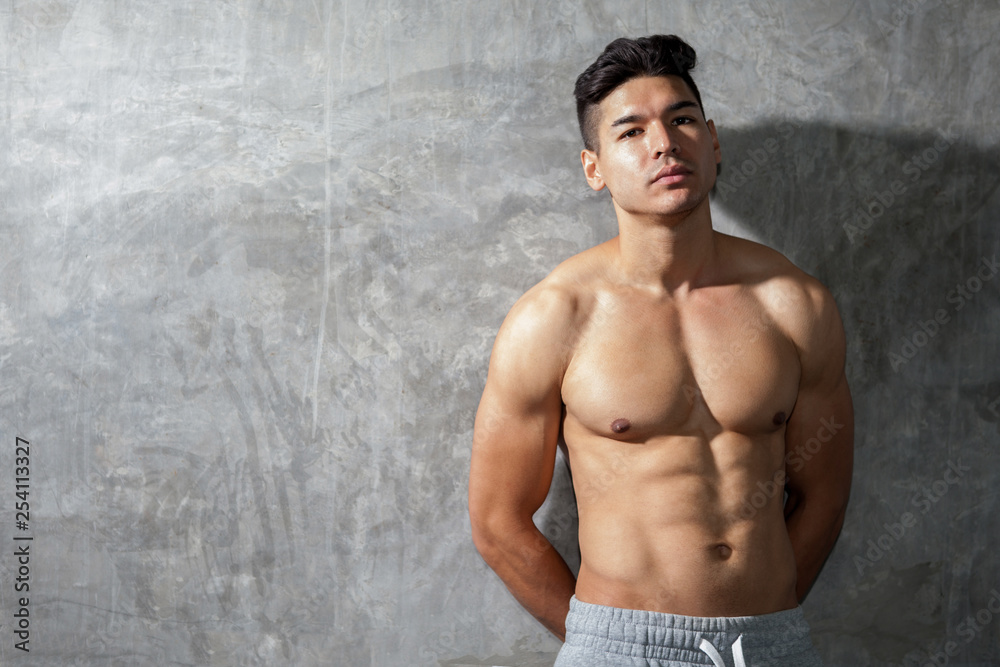 Handsome Muscular bodybuilder man showing his muscle body on gray ...