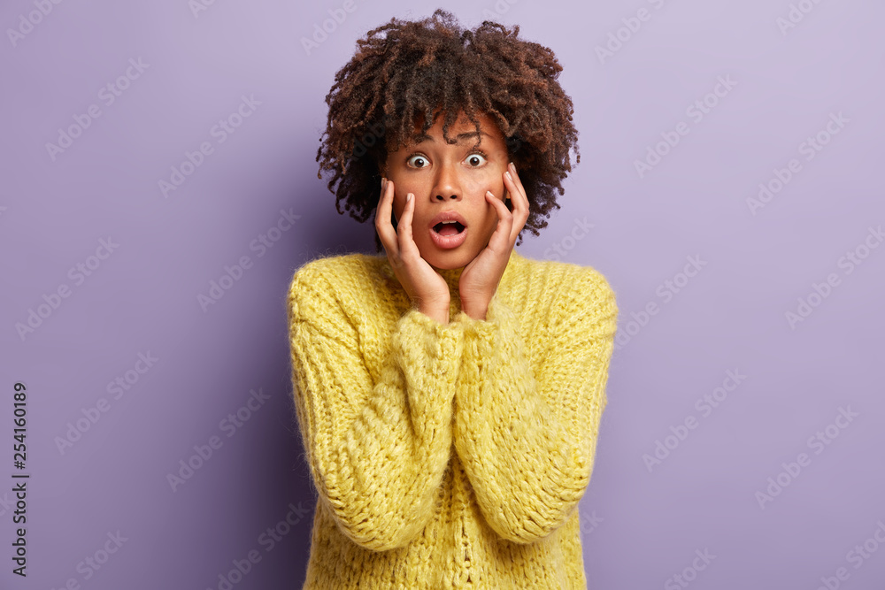 Oh no! Surprised frightened dark skinned girl opens mouth and eyes from ...