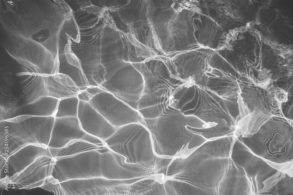 Black and white water surface with bright sun light reflections, water ...