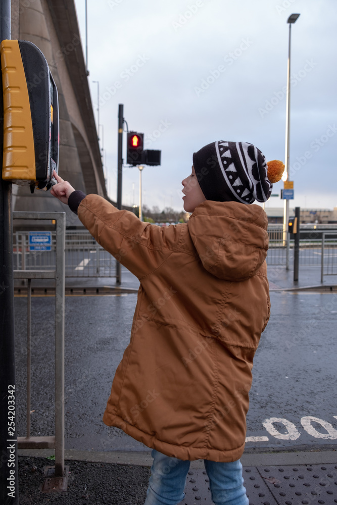 Little boy pushing the traffic light button to cross the road Stock ...