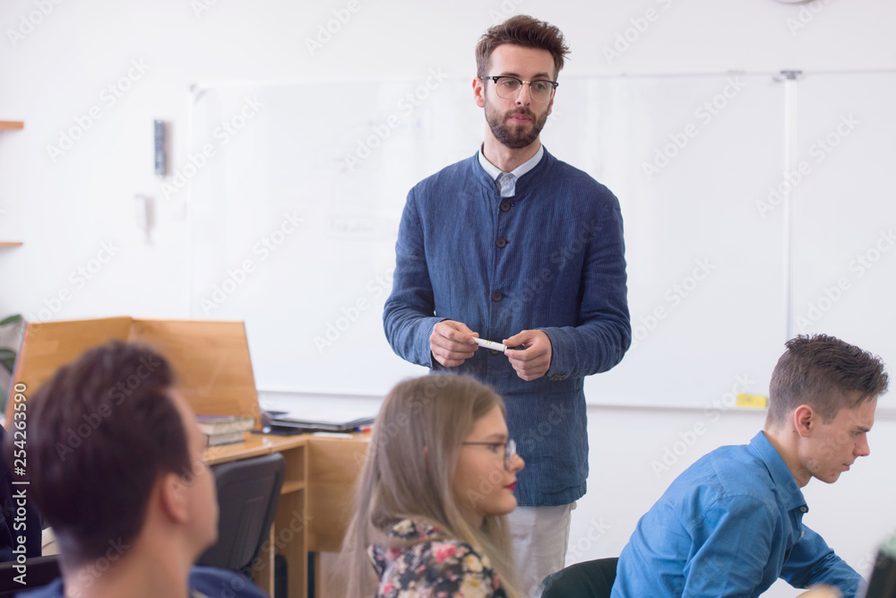 Group of students study with professor in modern school classroom. Male ...