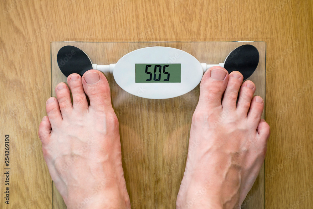 Man' s feet on weighing scale. Diet problems concept with weight scale ...