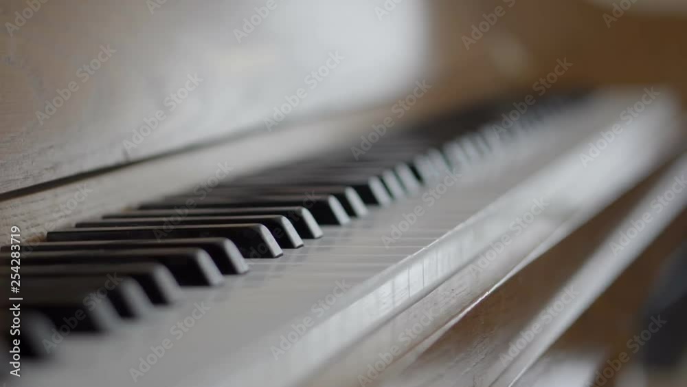 stand up piano keyboard with a shallow depth of field bokeh sliding ...