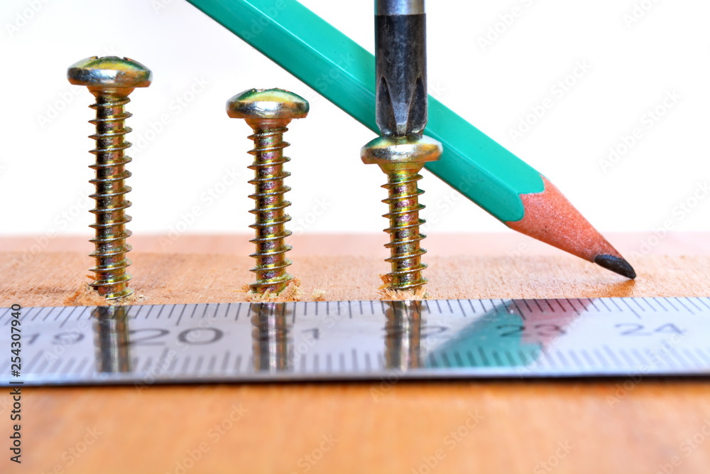 Three screws in a row screwed into a wooden Board and the head of a ...