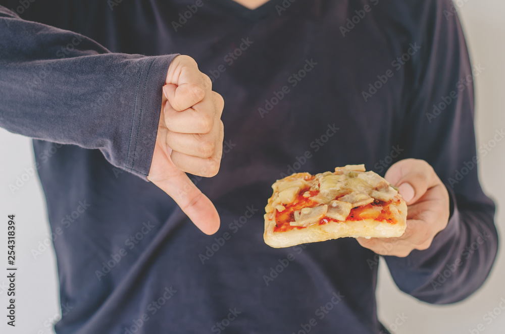 Young man rejecting pizza or unhealthy food showing thumbs Down ...