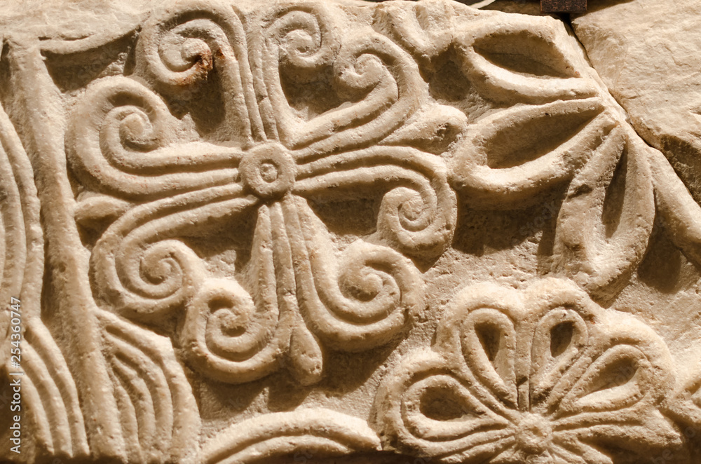 Romanesque decorations carved in the stone wall of an ancient medieval ...