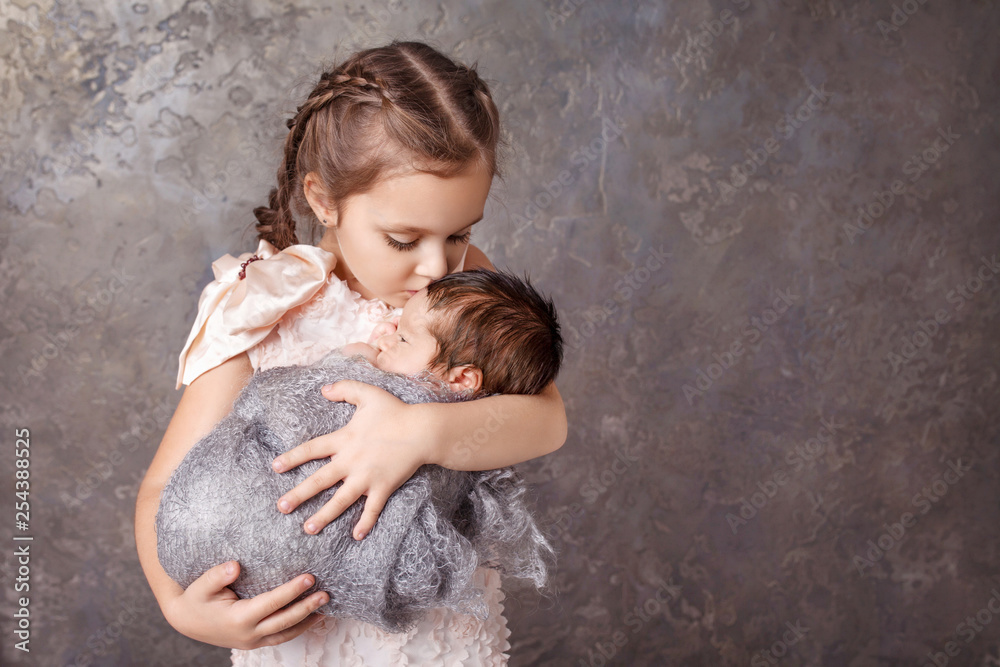 Newborn baby with sister. Cute girl holding her little brother. Happy ...