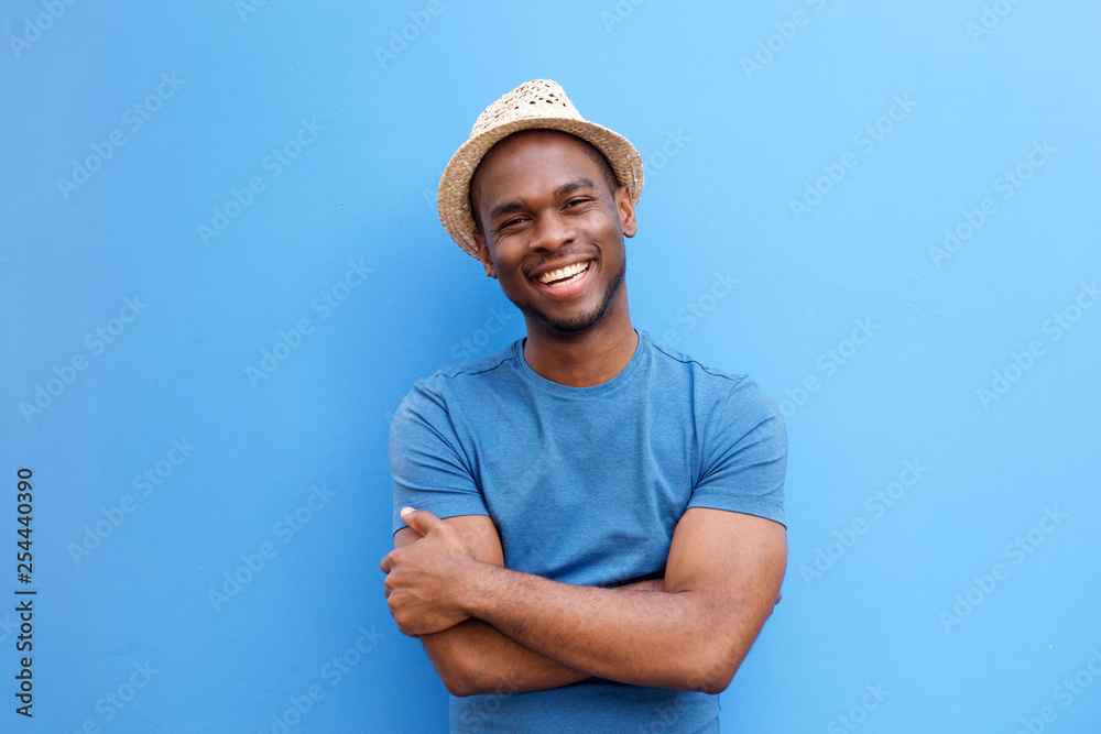 handsome young black guy smiling with hat against blue background Stock ...