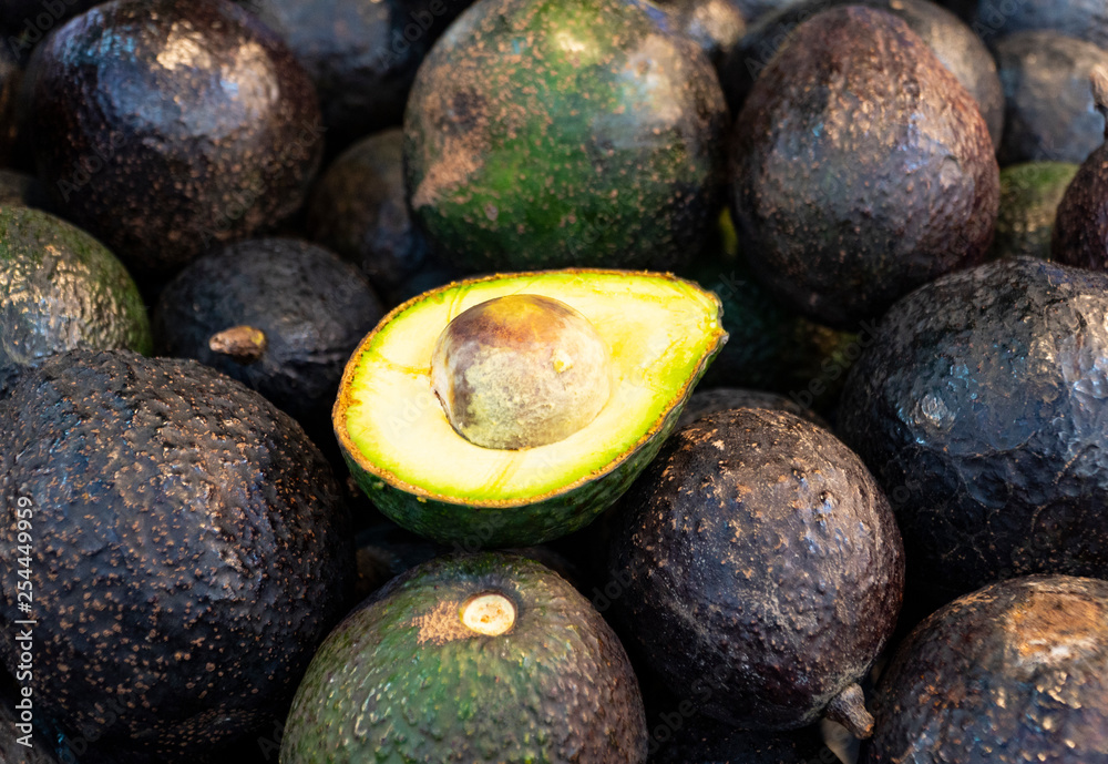 Avocado, a half opened fruit with its creamy pulp and a single seed ...