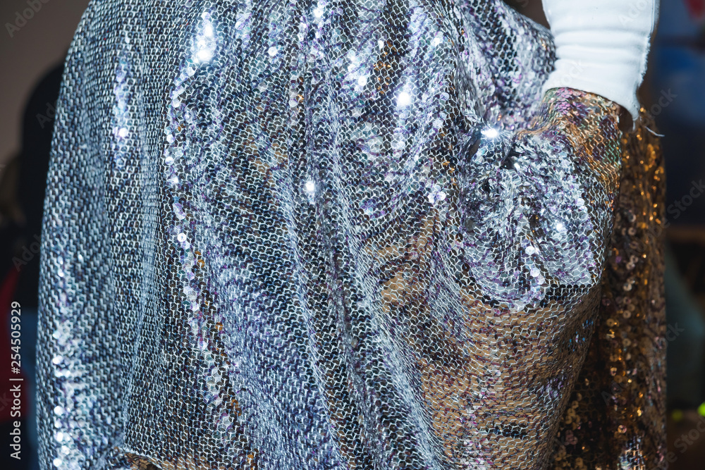 Texture of fabric with sequins. A woman in a shiny Cape. Cloak ...