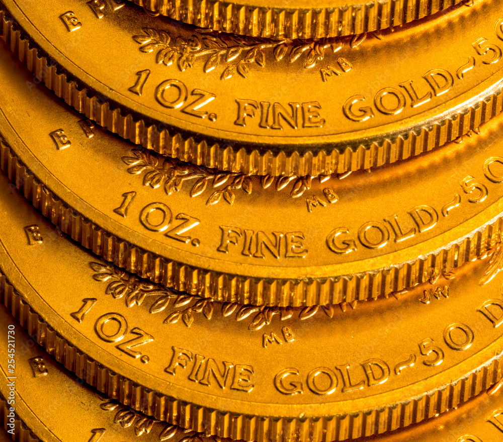 Stack of golden coins using US Treasury issue Gold Eagle one ounce pure ...