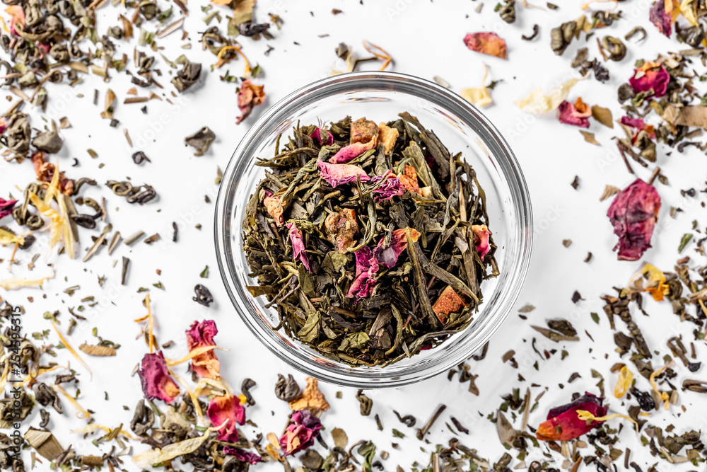 Green tea with dried flower petals and pieces of citrus in a glass bowl ...