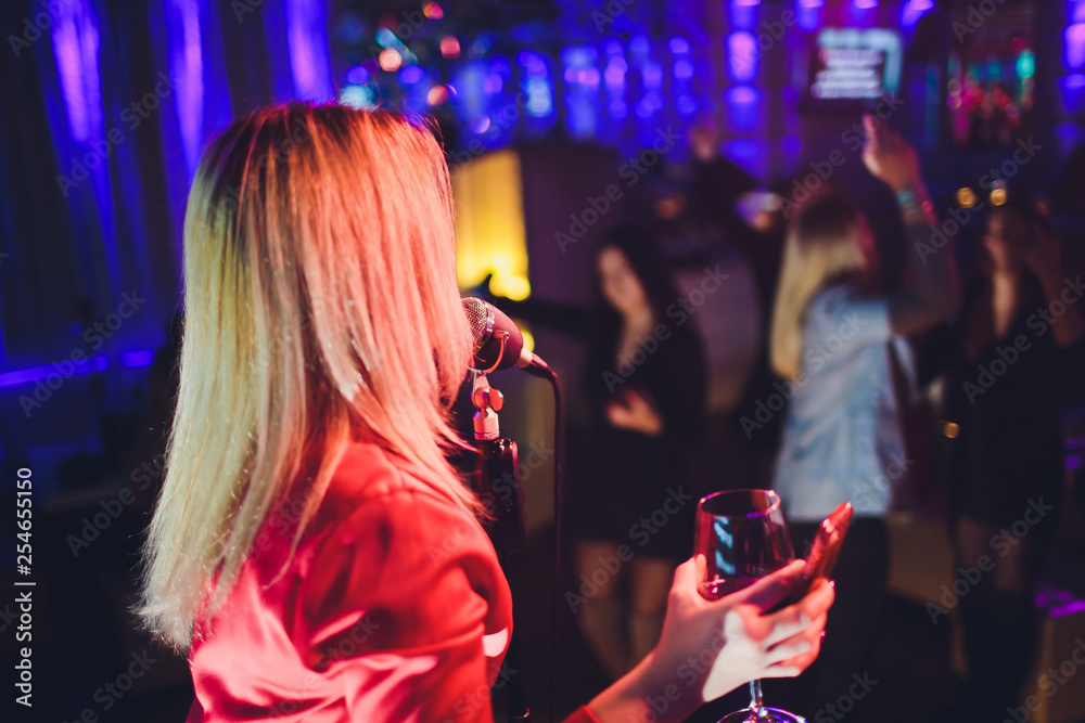 Girl in long gown performing on stage. Girl singing on the stage in ...
