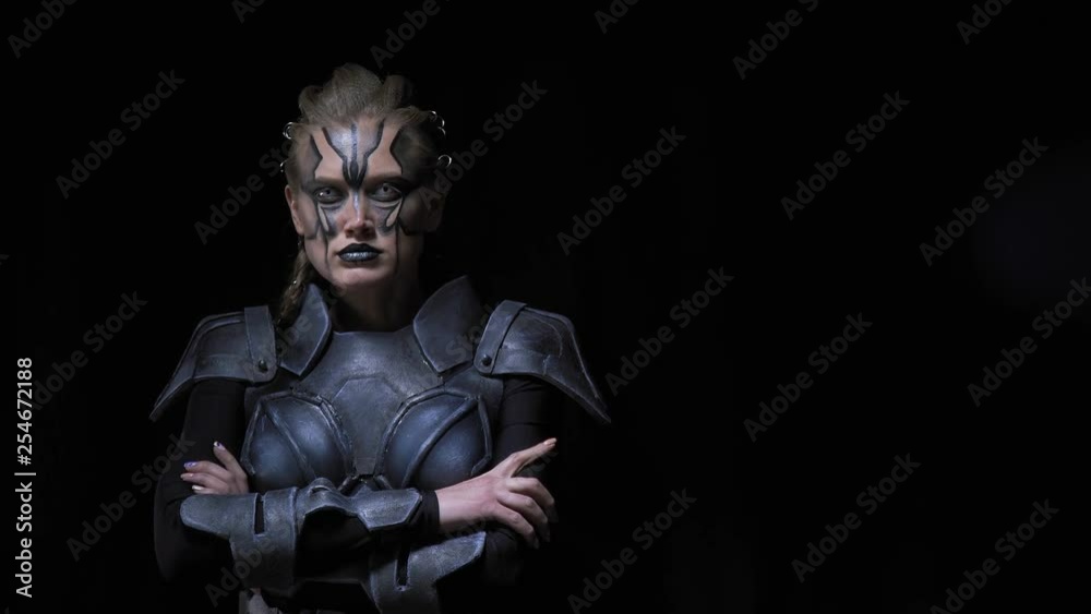 Scary futuristic alien in metal armor, with dreadlocks and white eyes ...