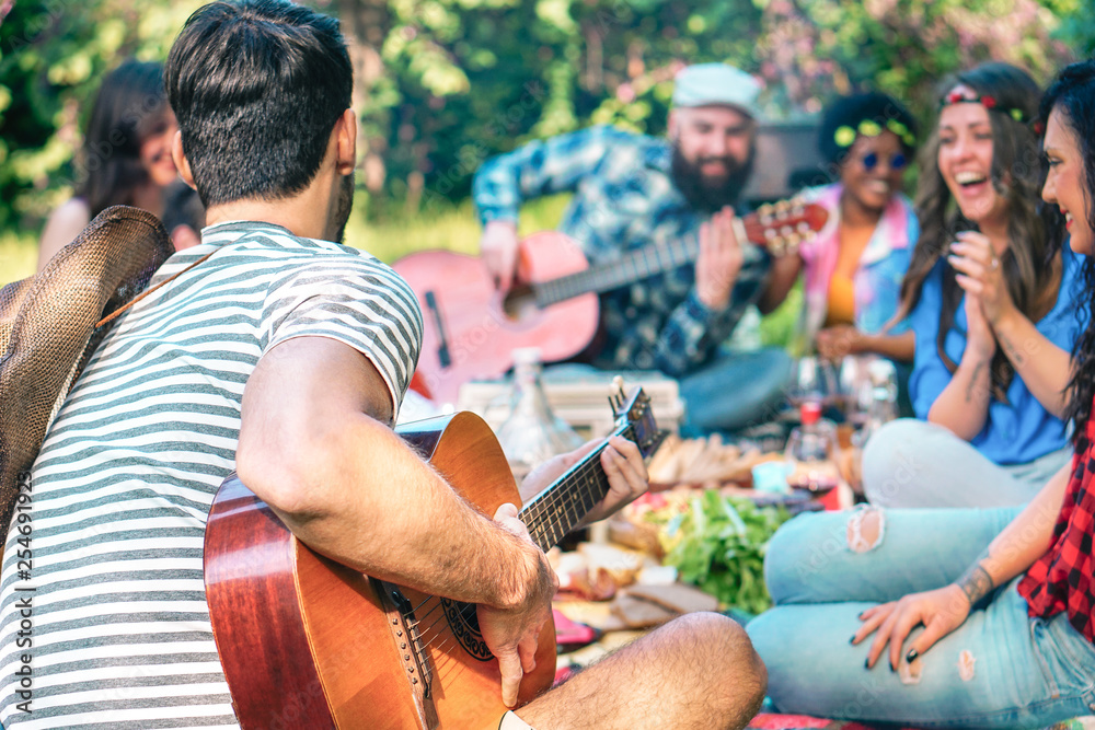 Young people doing picnic and playing guitar in park - Group of happy ...
