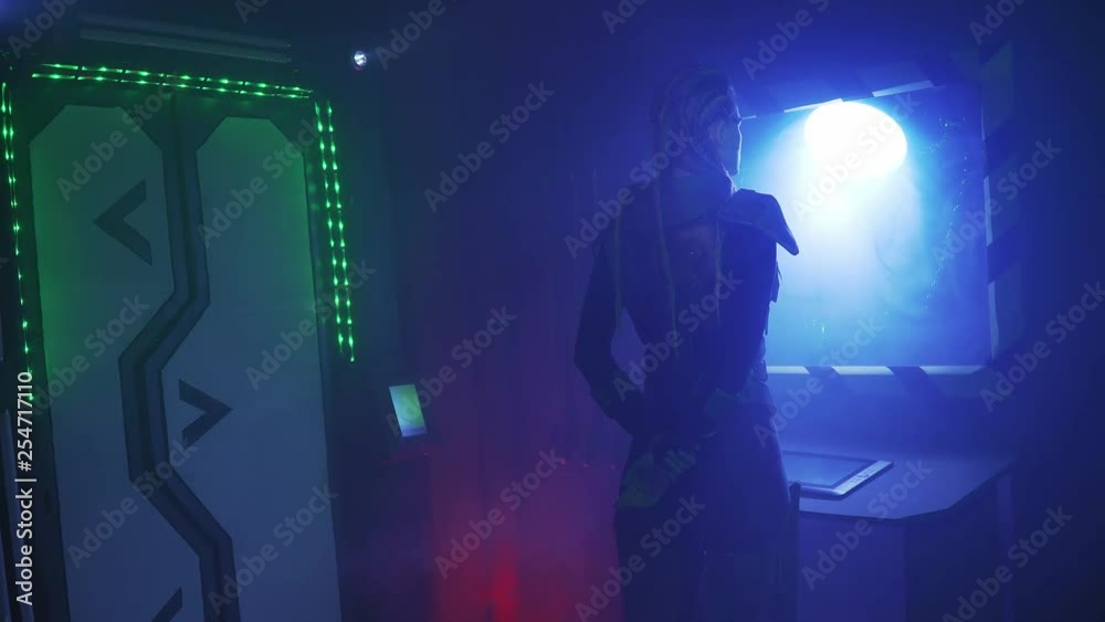 An alien spaceship, a woman in metal armor, with long dreadlocks is ...